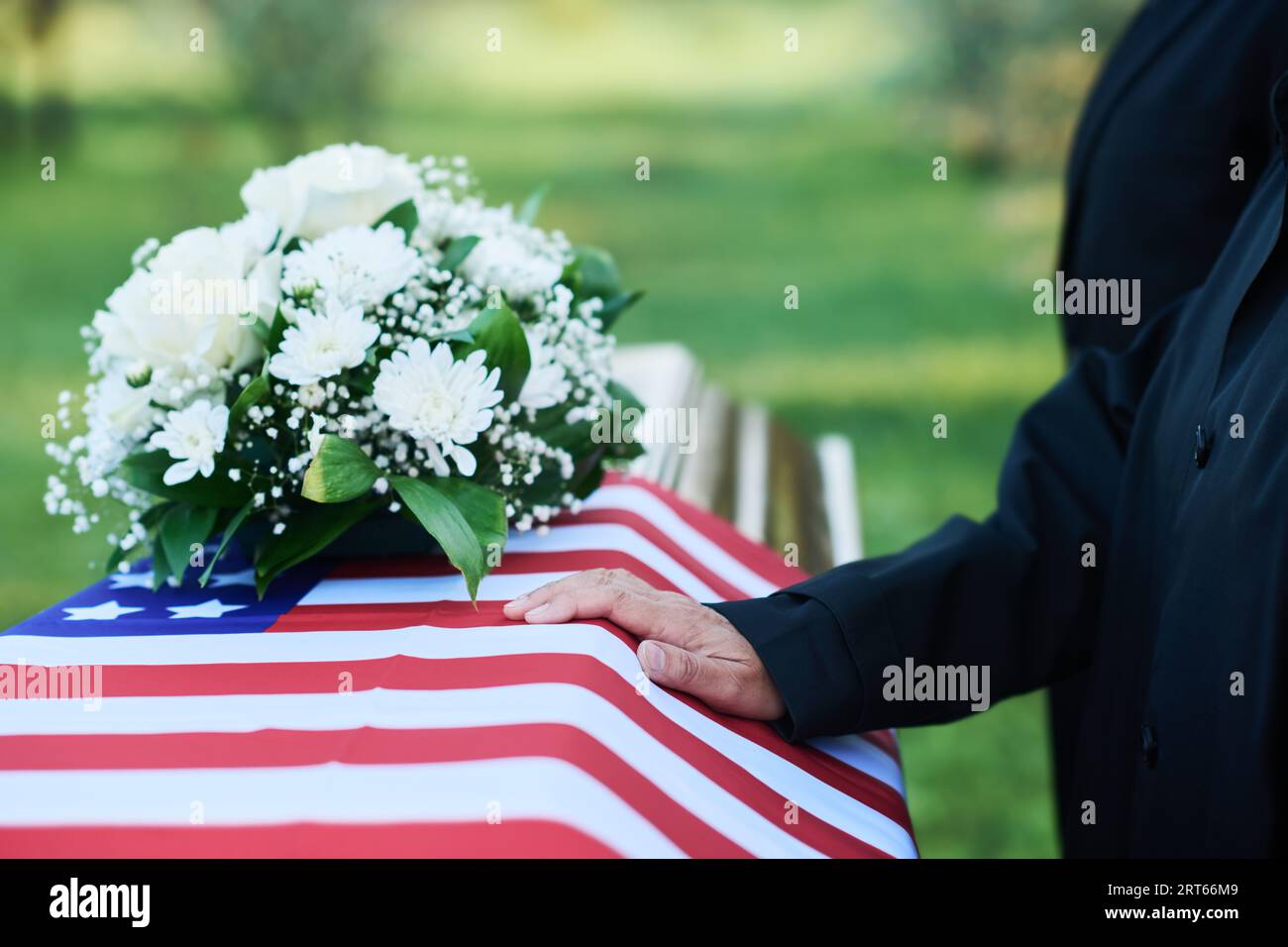 Hand of mature woman in mourning attire on American flag covering ...