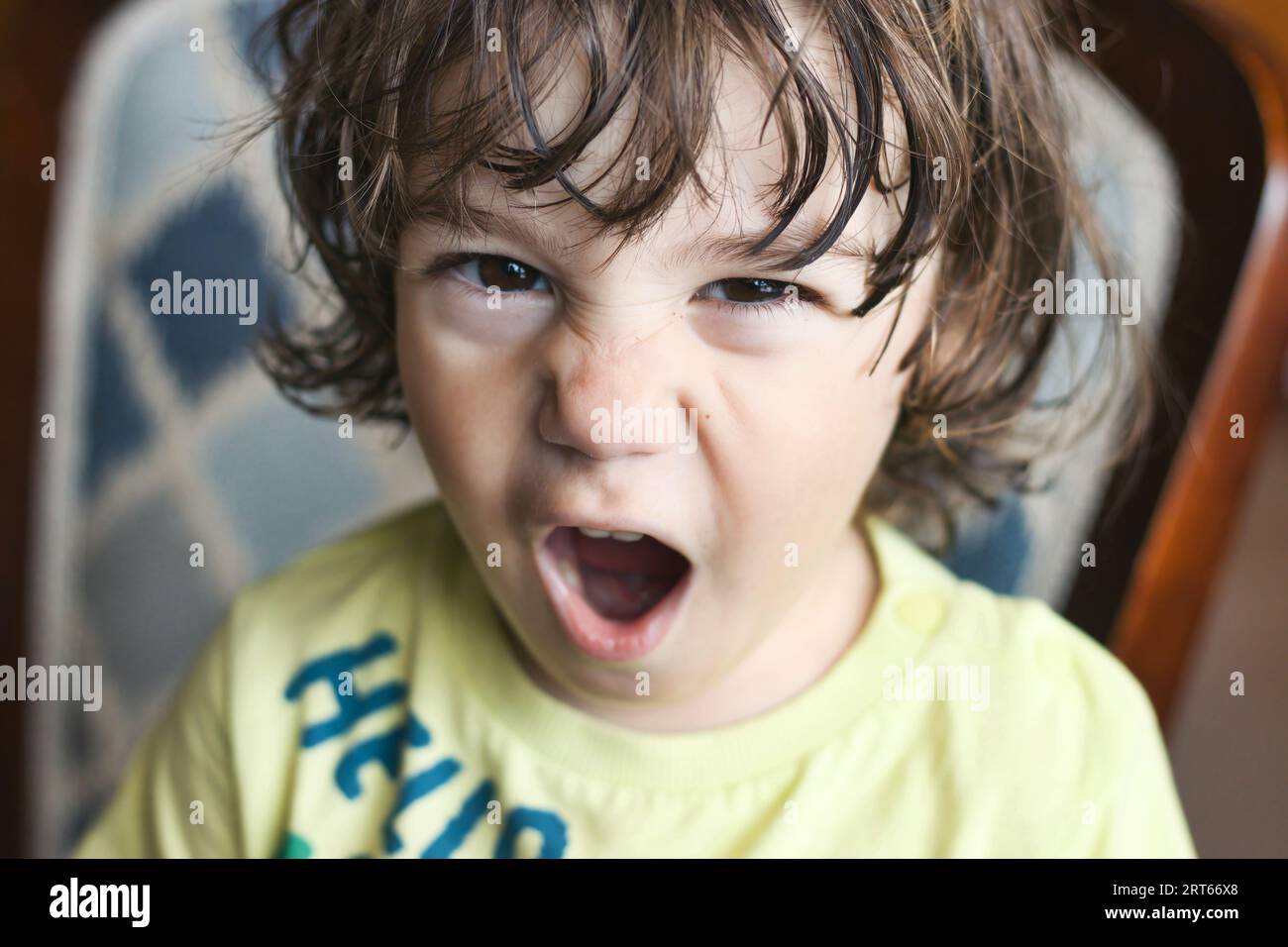 Closeup headshot portrait of a young white Caucasian boy throwing a ...