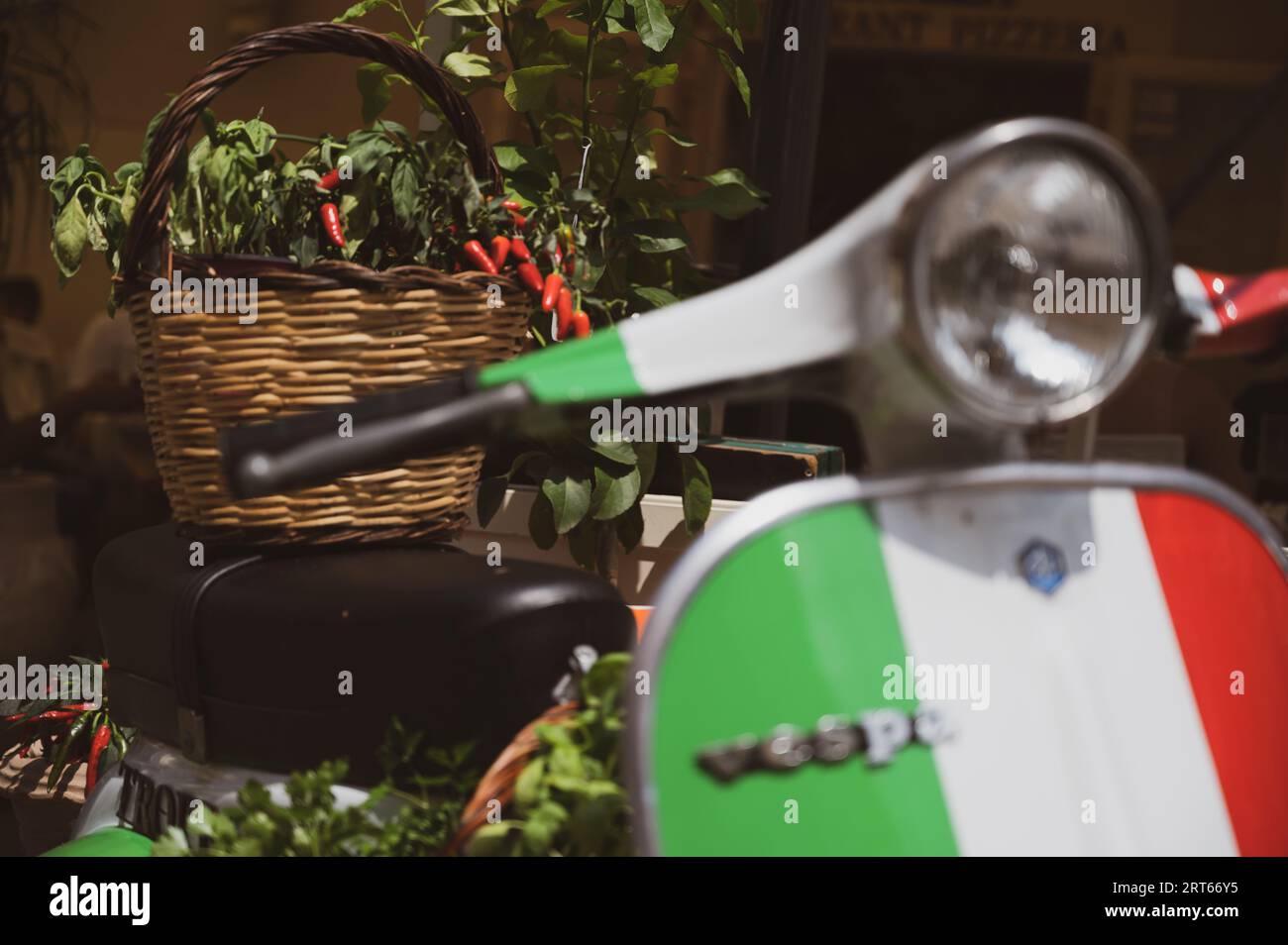 A Vespa Piaggio motorcycle with a basket of chilies on display in ...