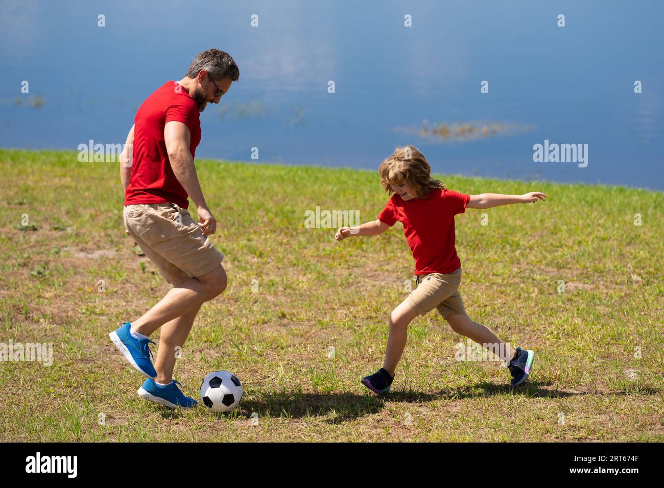 Dad with his little cute son are having fun and playing football on ...