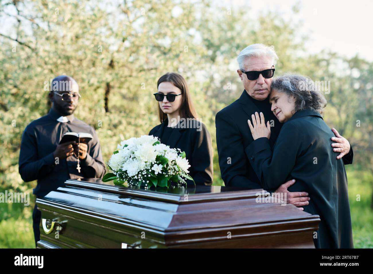 Mature man supporting his inconsolable wife while both grieving about ...