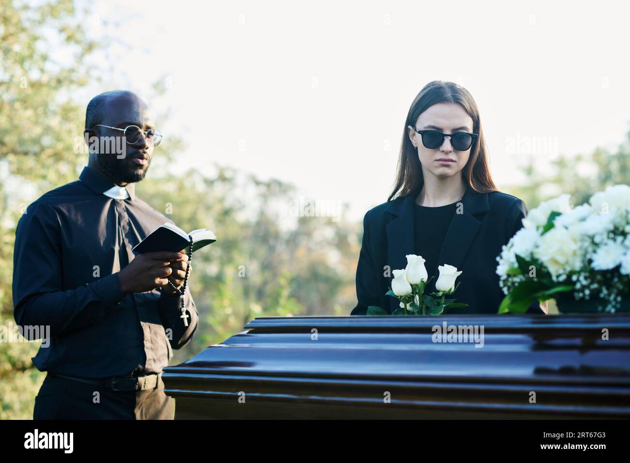 Young inconsolable widow in mourning attire and sunglasses holding ...