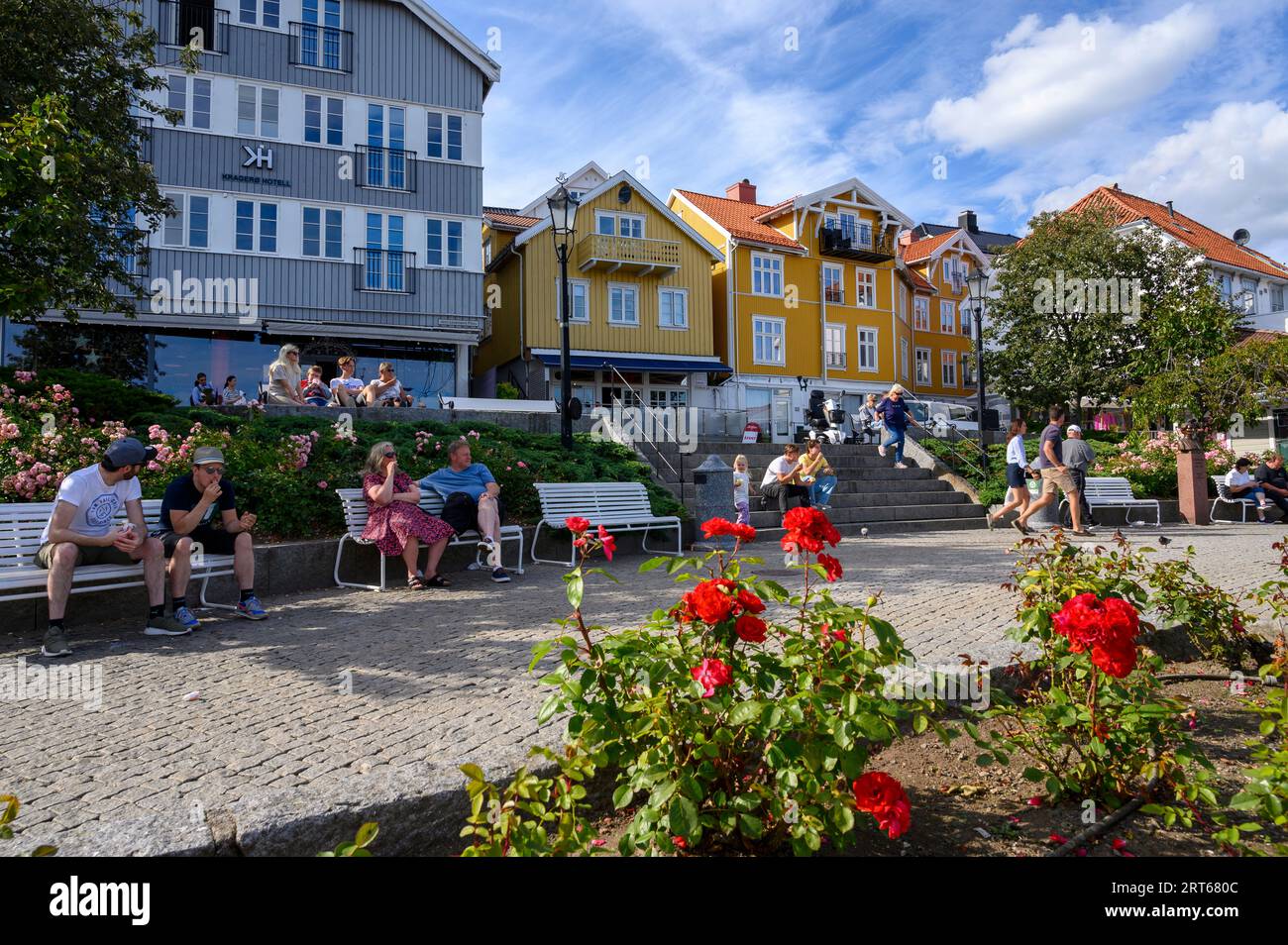 People sitting on park benches watching the world go by in the well ...