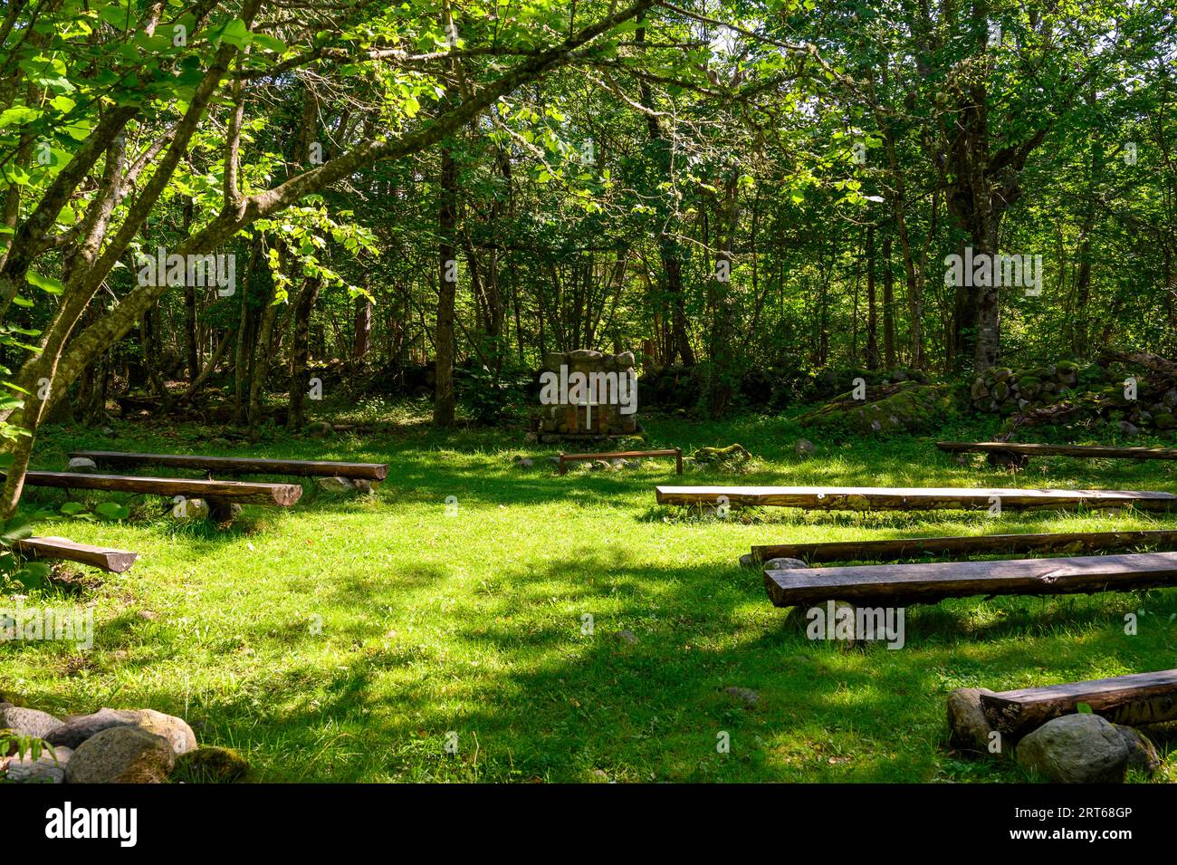 The open air public church with basic altar and timber benches in green ...