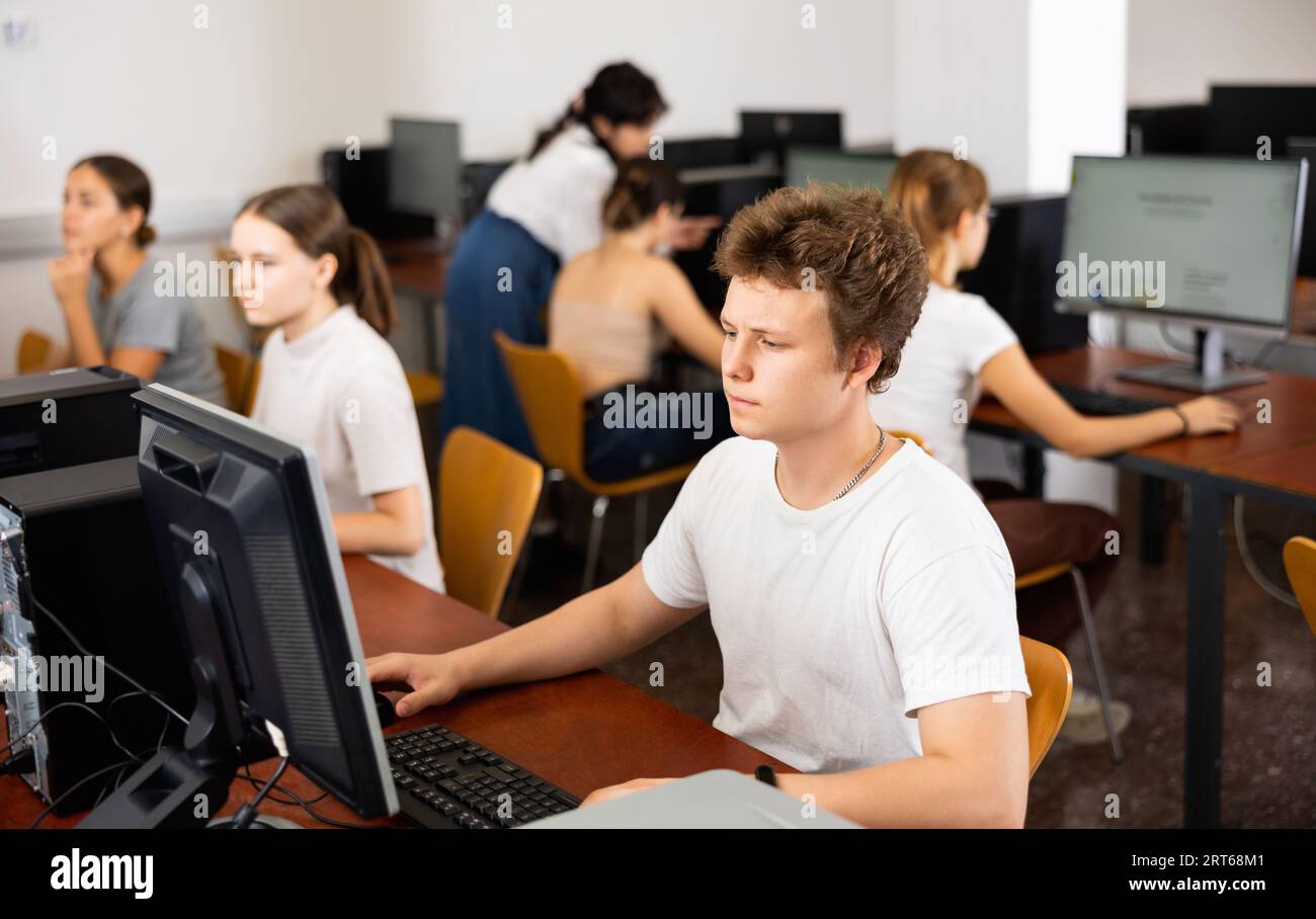 Teenage boy learning to use personal computer during lesson Stock Photo ...