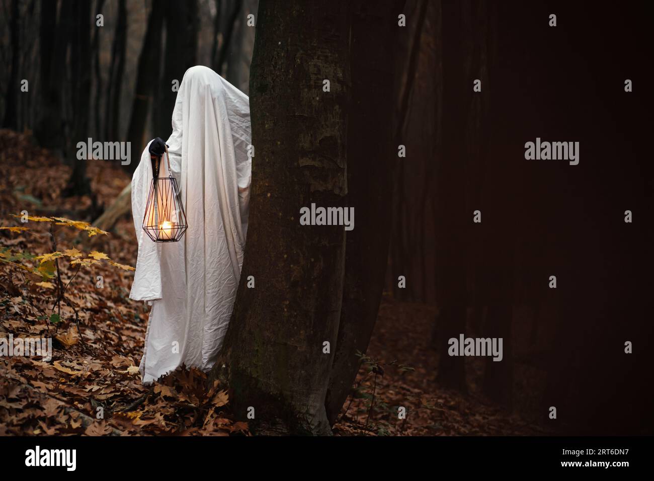 Boo! Happy Halloween! Spooky ghost holding glowing lantern and peeking ...