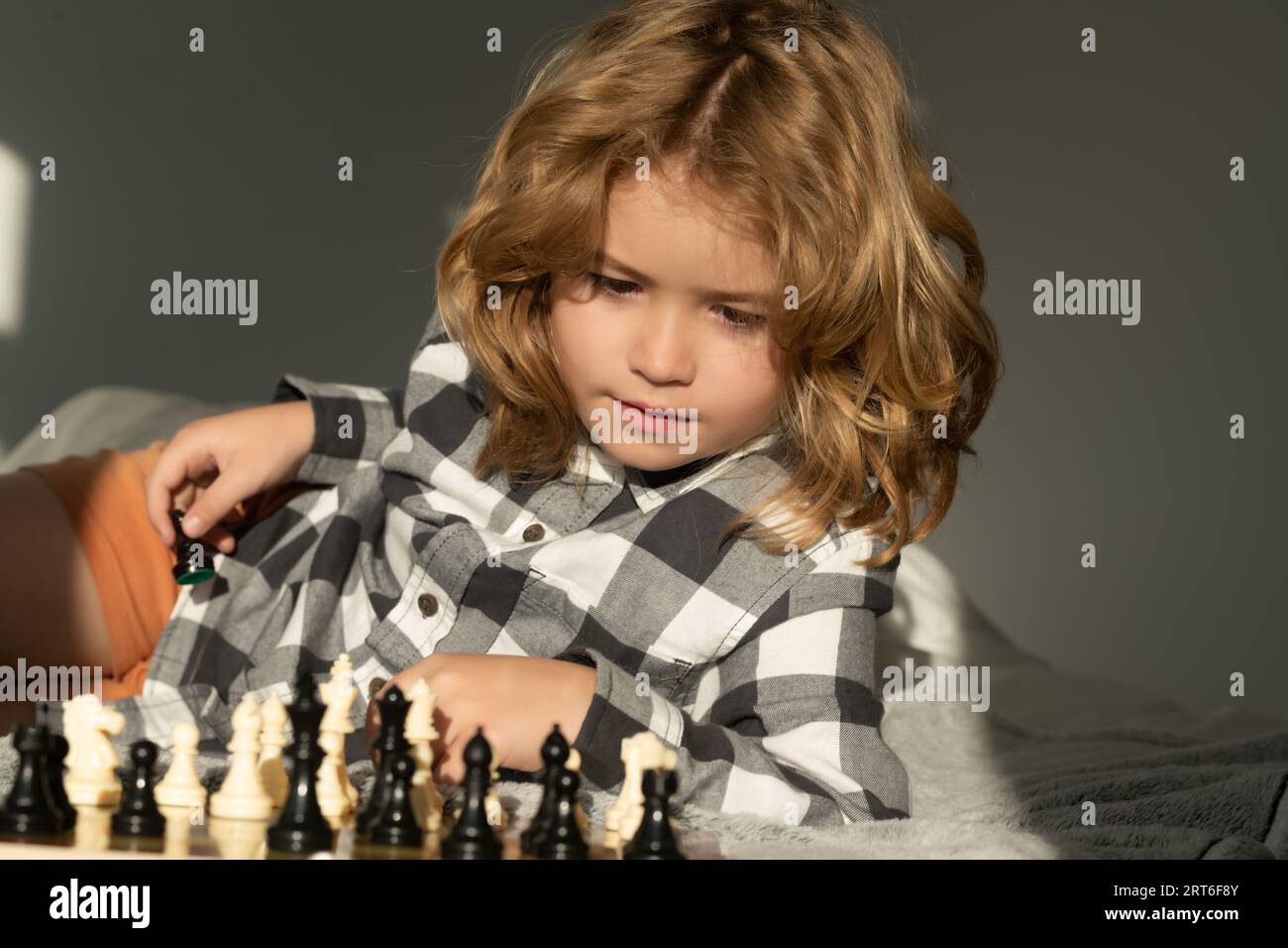 Child playing chess at home. Chess school. Child think about chess game ...