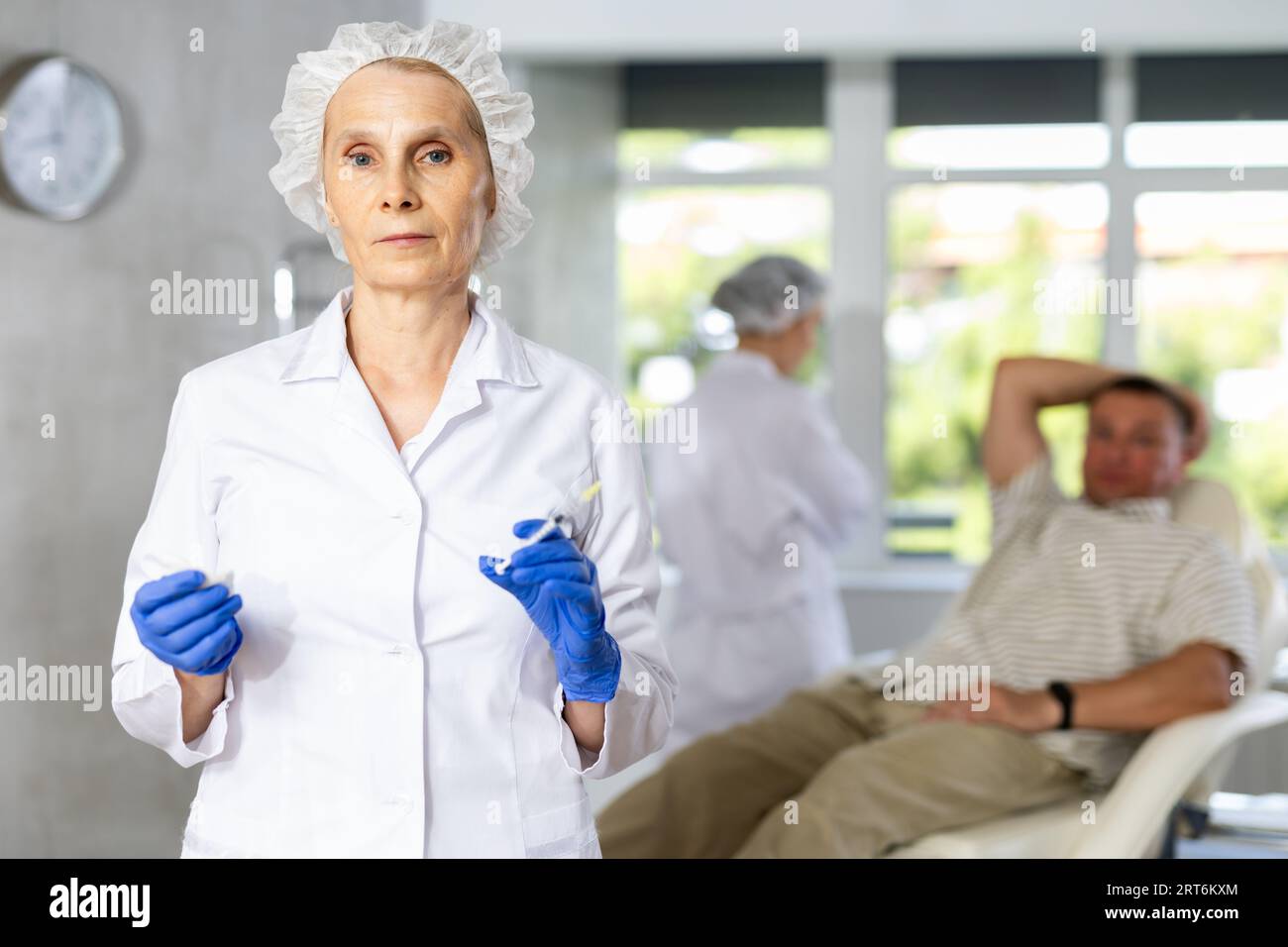 Portrait of nurse with a syringe in her hands before injecting patient ...