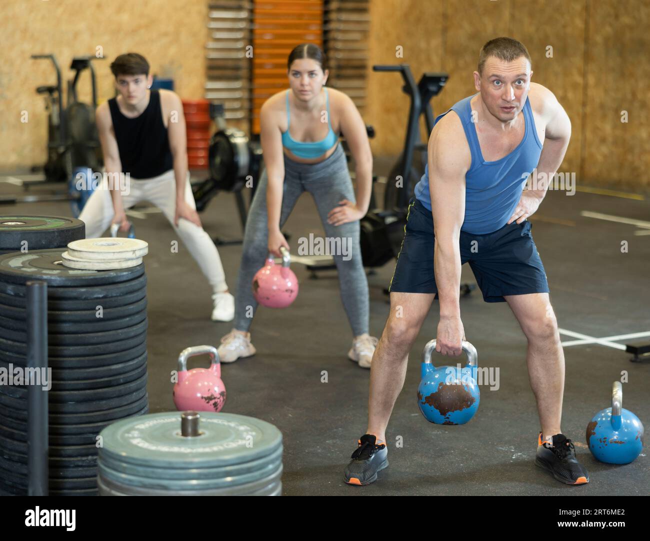 Concentrated man exercising with kettlebell during intense training ...