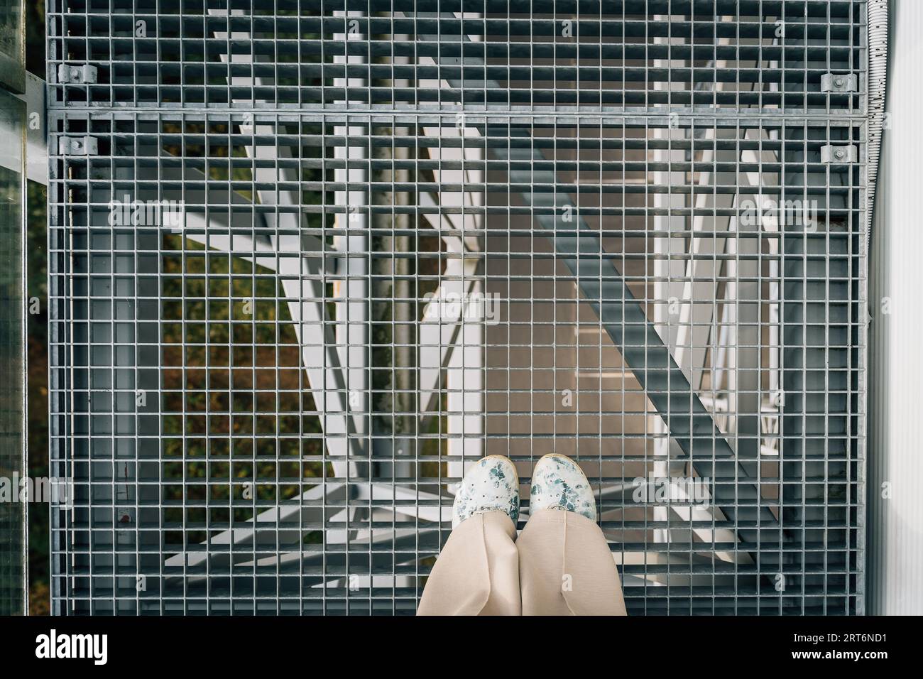 Elevated Perspective: woman feet on suspended mesh metalic bridge Stock ...