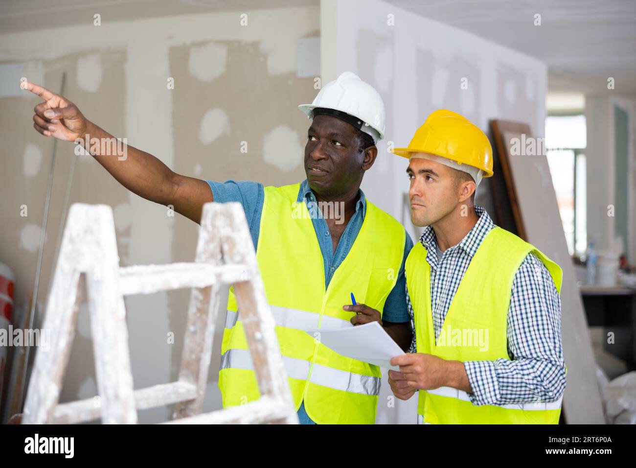 Man and man builders discussing project documentation Stock Photo - Alamy