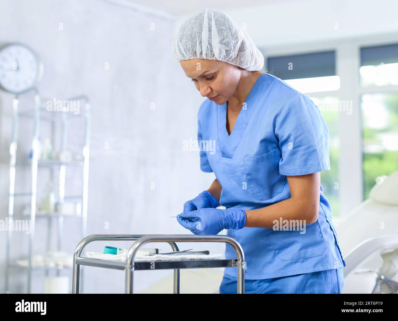 Focused female doctor preparing syringes for injection in clinic office ...