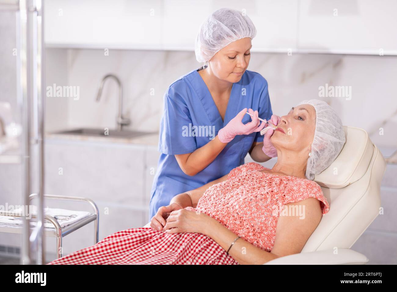 Qualified cosmetologist giving beauty injections for face skin ...