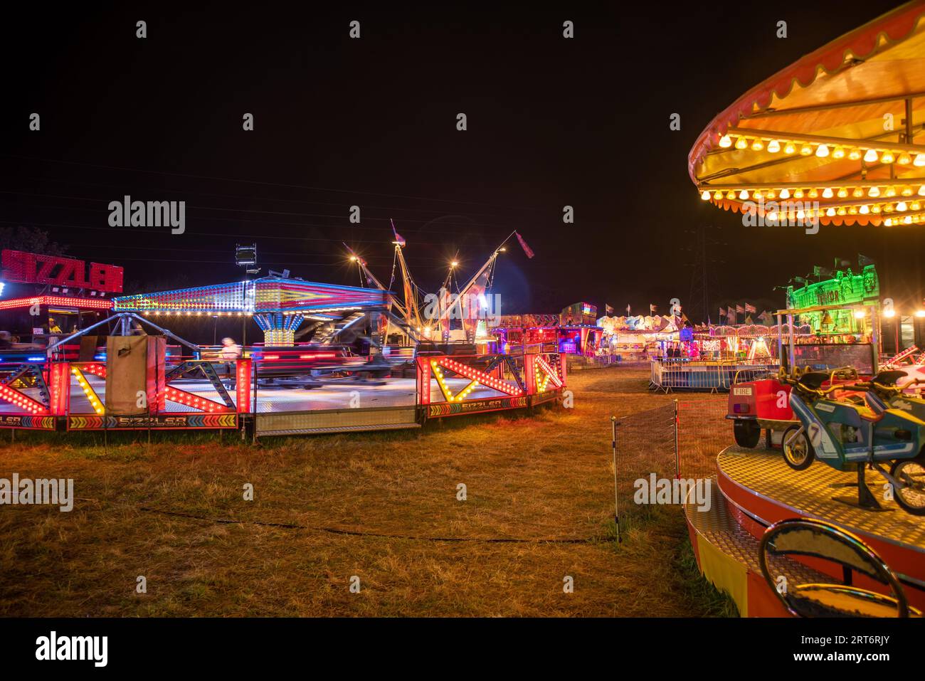 A festive nighttime scene of a bustling carnival fairground Stock Photo ...