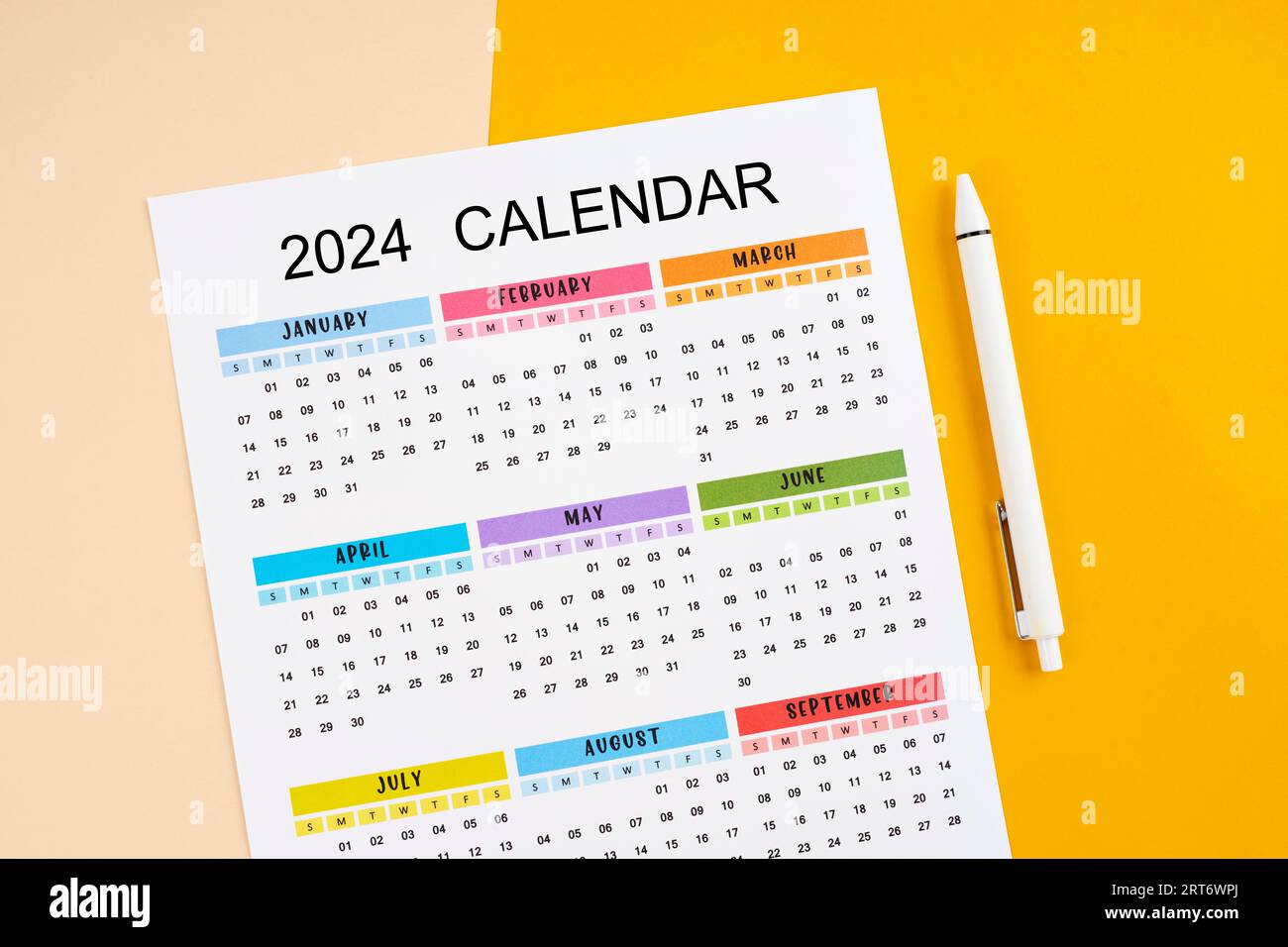 12 months desk calendar 2024 and pen on yellow background Stock Photo ...