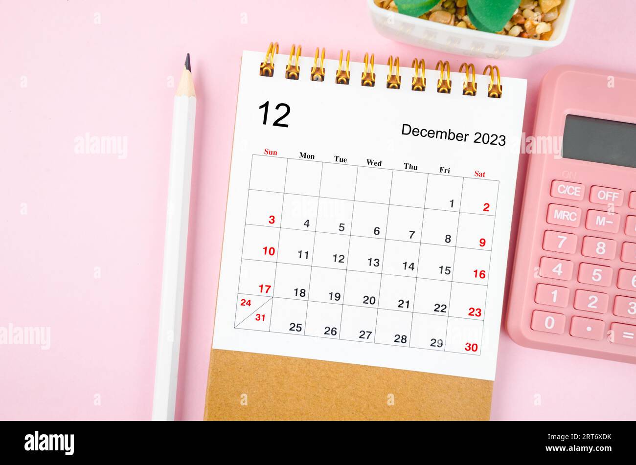 December 2023 desk calendar for 2023 year with calculator on pink color ...