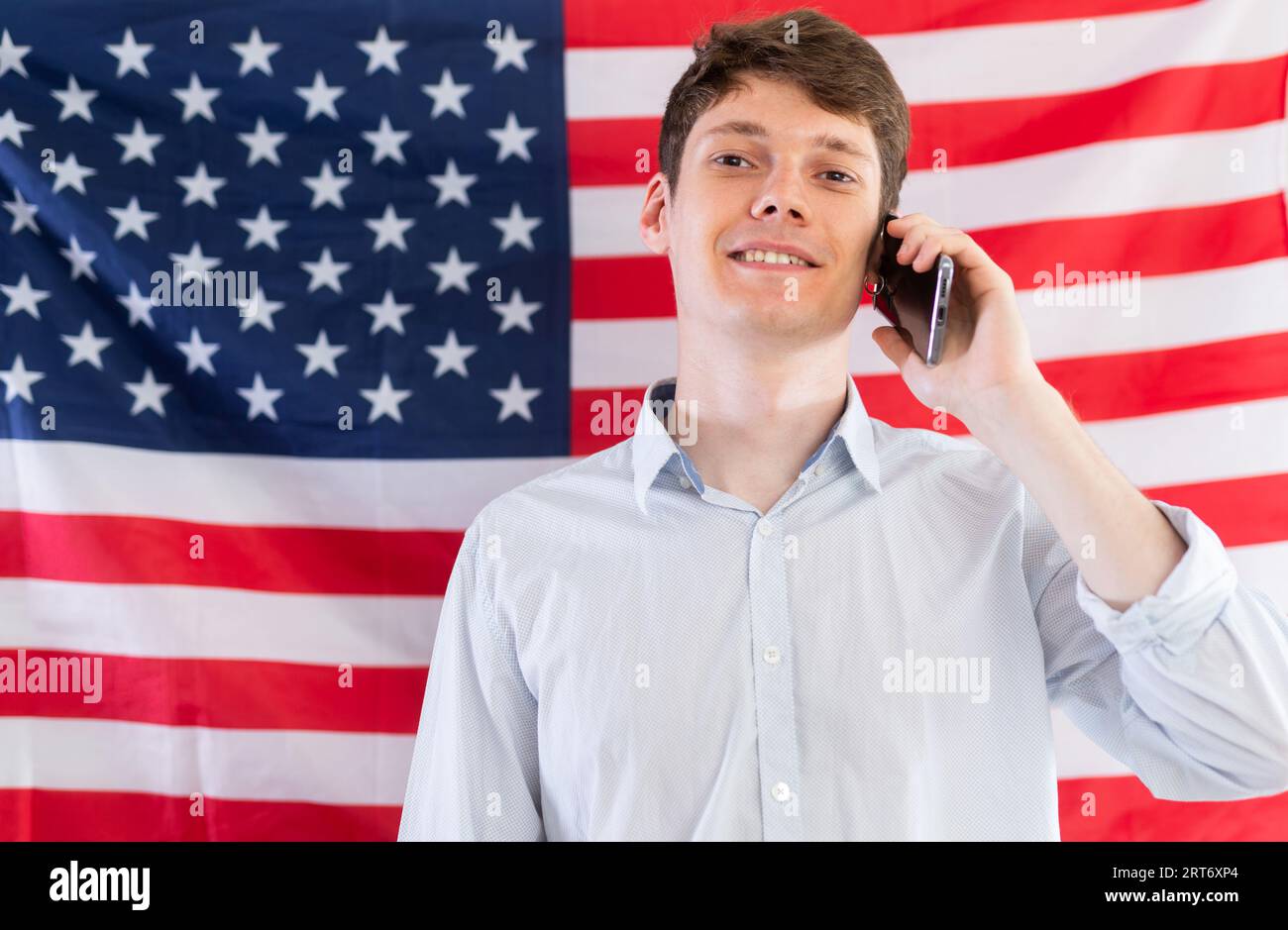 Young guy talking on phone on background of USA flag Stock Photo - Alamy