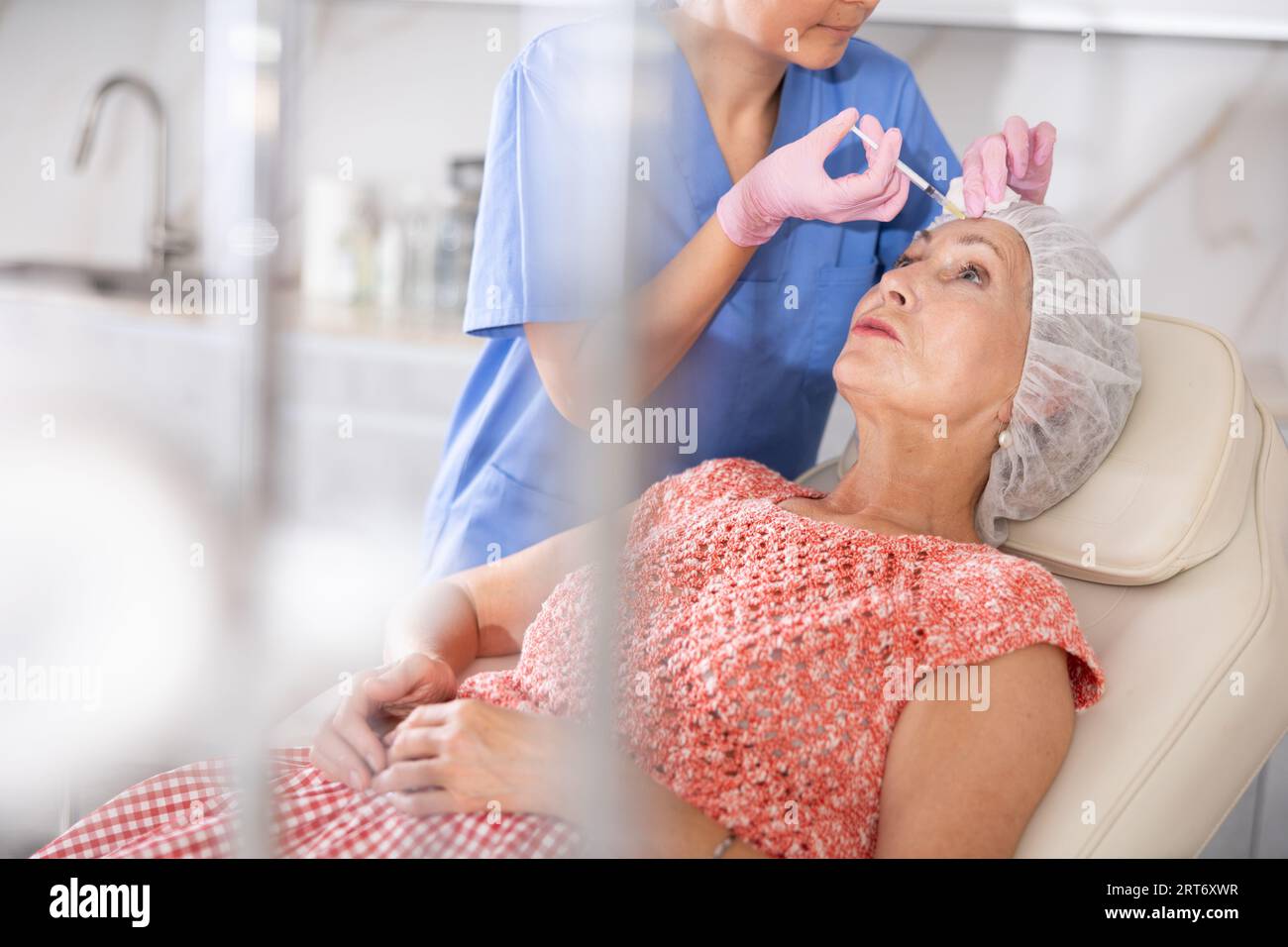 Female doctor gives injection of botulinum toxin to elderly woman ...