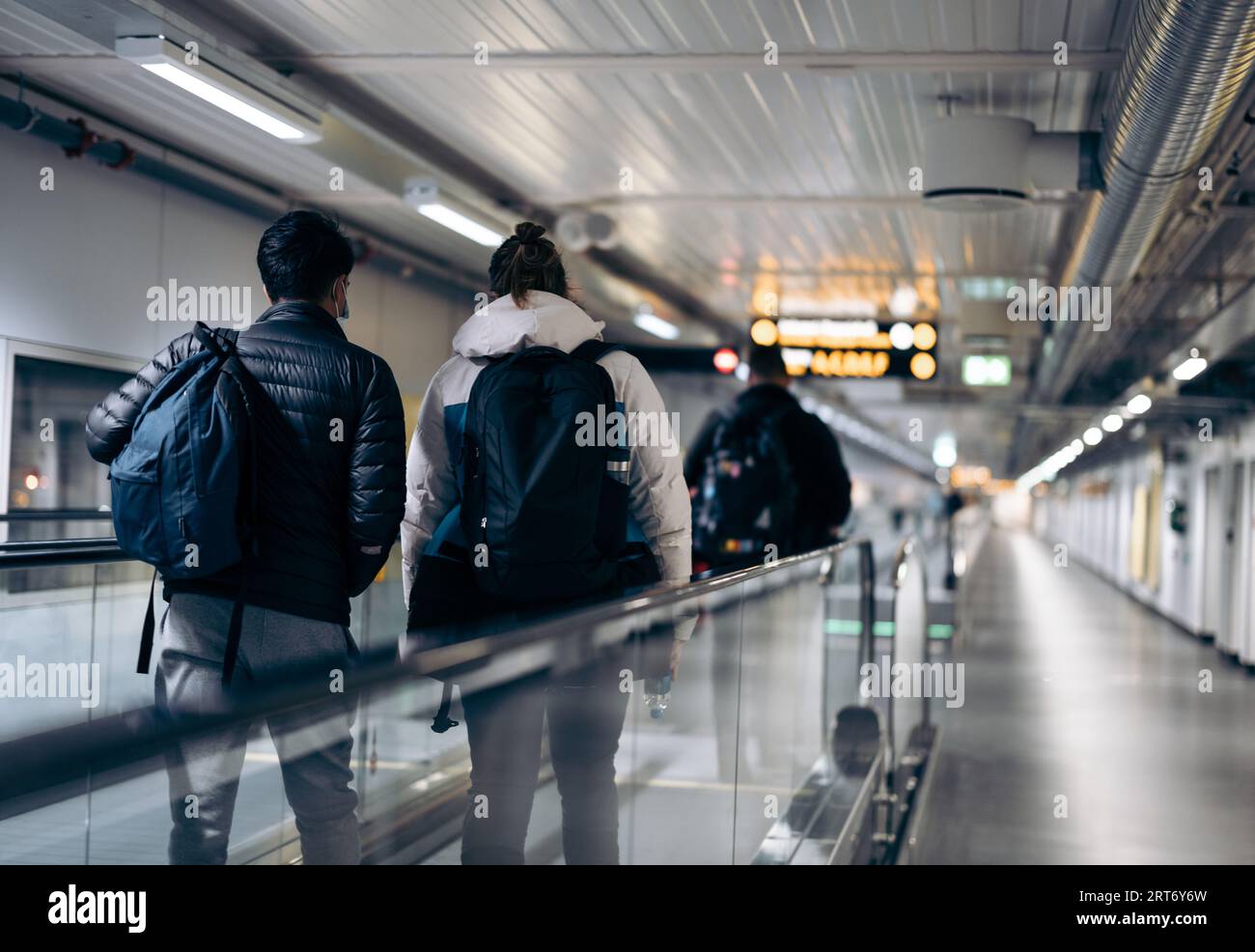 Back view of anonymous male and female passengers with backpacks ...