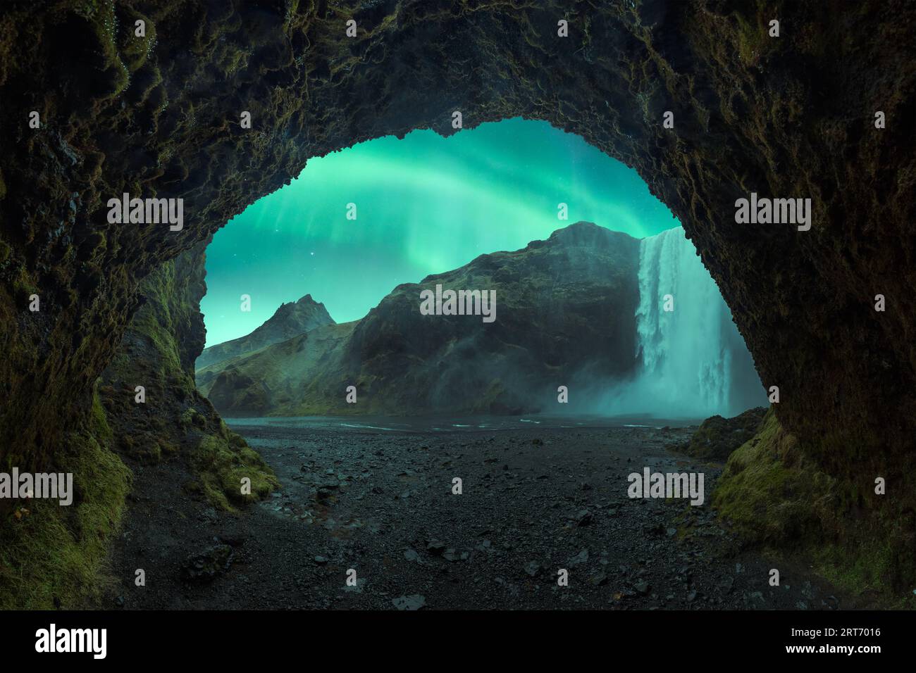 Picturesque scenery from cave of powerful waterfall and green aurora ...