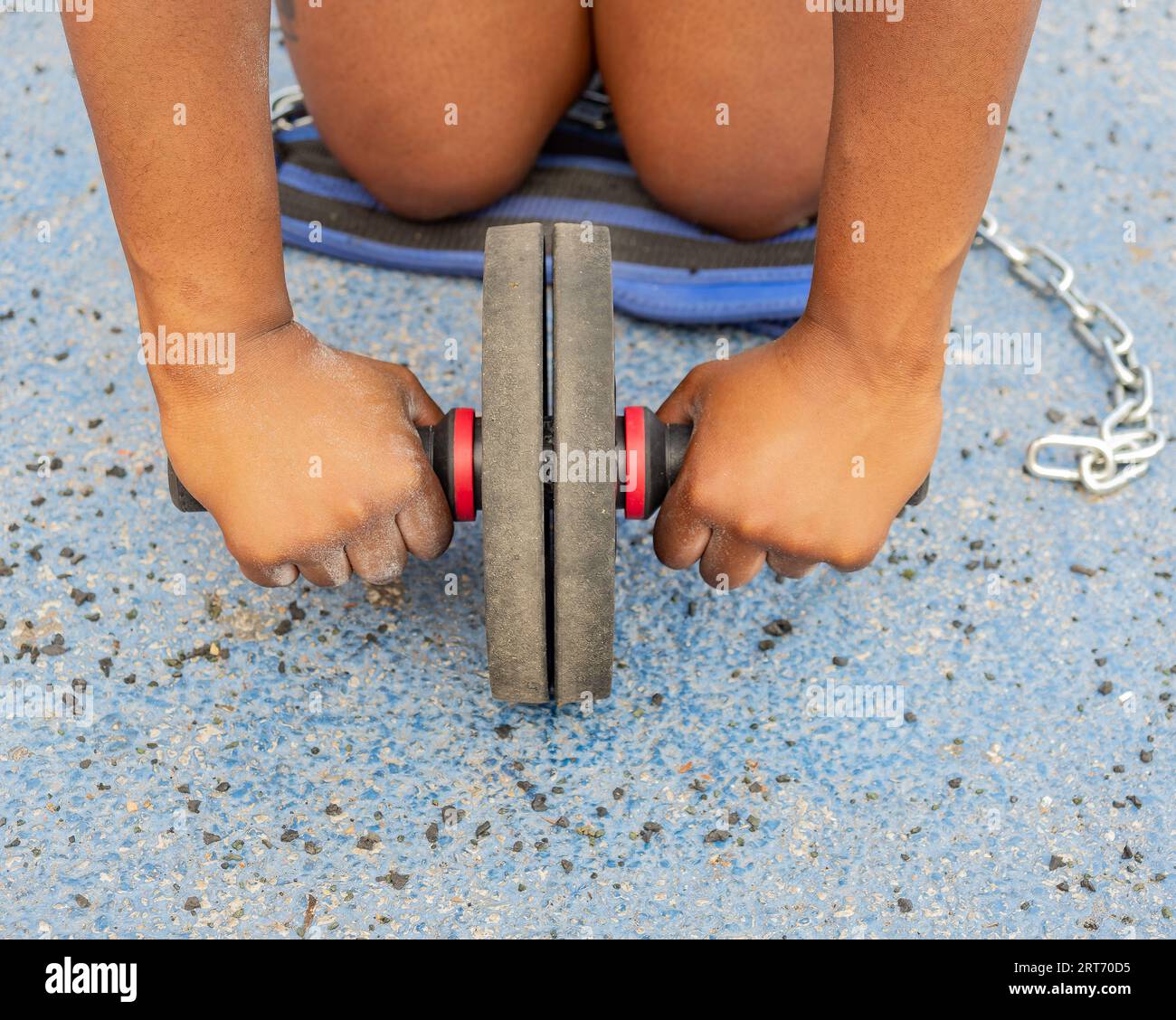 Unrecognizable of focused sporty black lady kneeling while working out ...