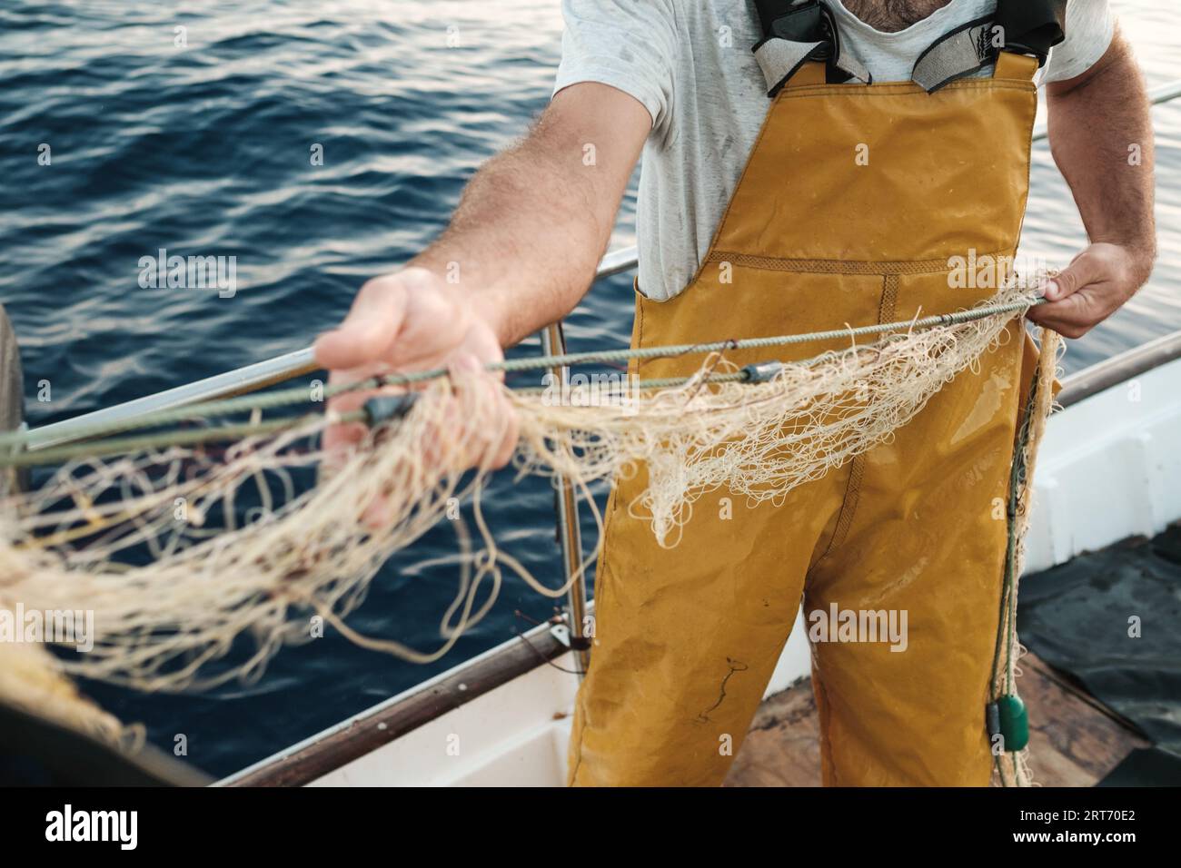 From above cropped unrecognizable male fisher in uniform seiner hunting ...