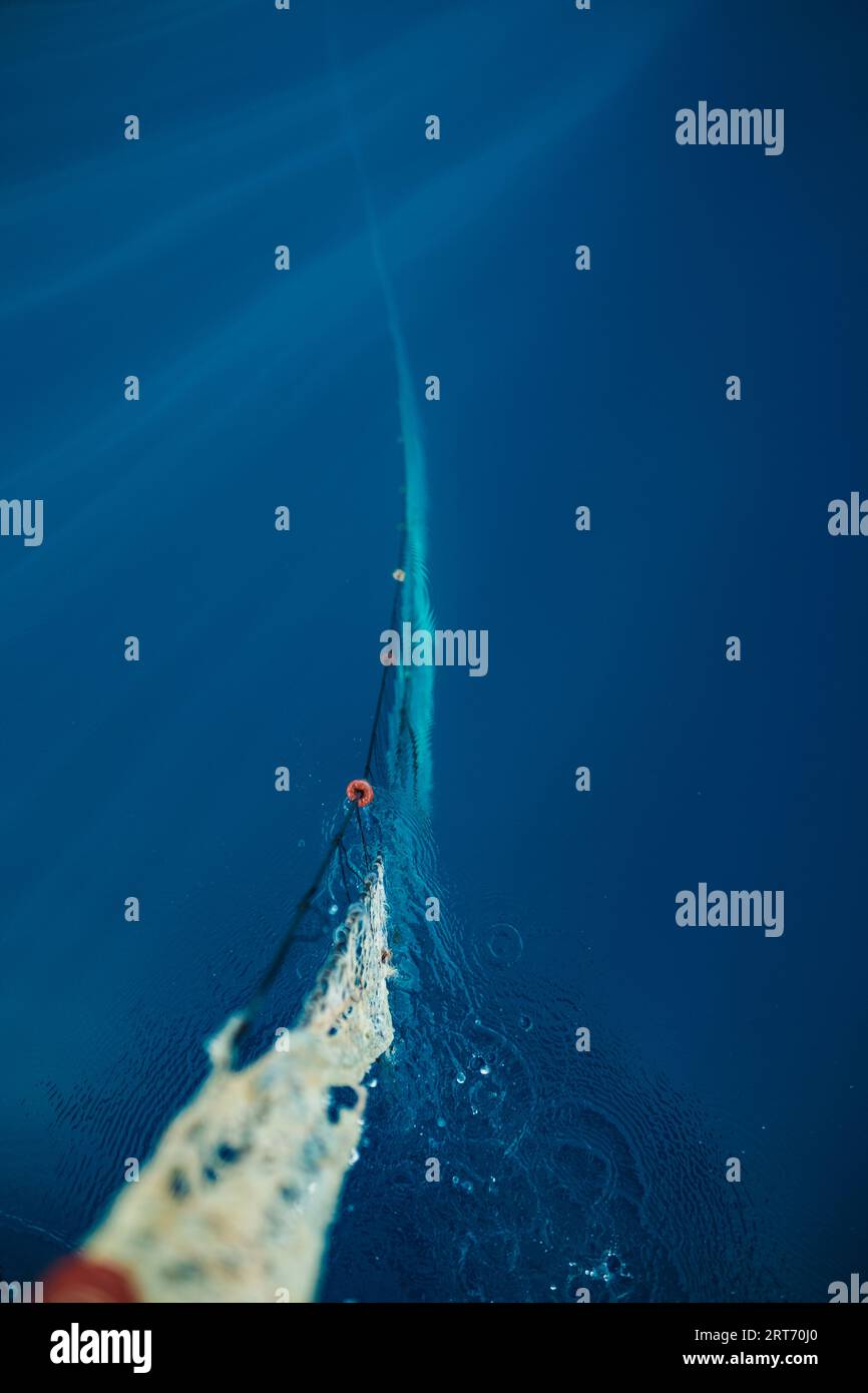 Large net with ropes floating in deep blue sea water under sunlight ...