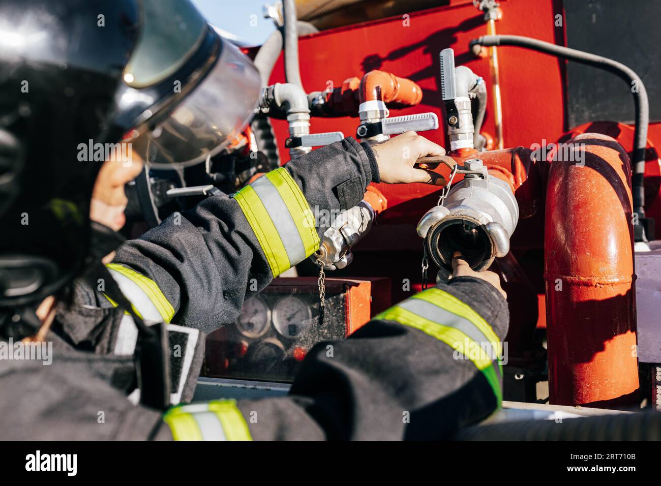 Crop anonymous firefighter in professional uniform and protective ...