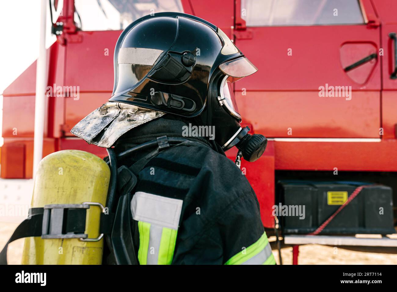 Back view of anonymous female firefighter in protective uniform and ...