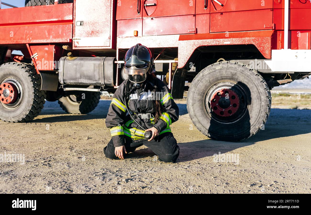 Anonymous female firefighter wearing uniform and protective mask ...