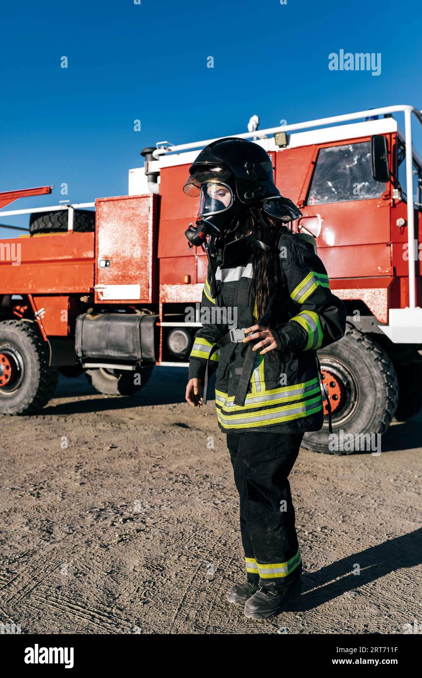 Full body of female firefighter in protective respirator and uniform ...
