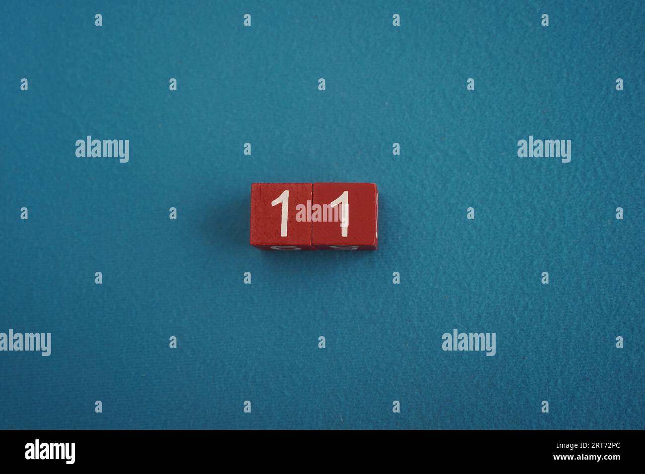 Wooden Viva Magenta cubes with number 11 on blue background close-up ...