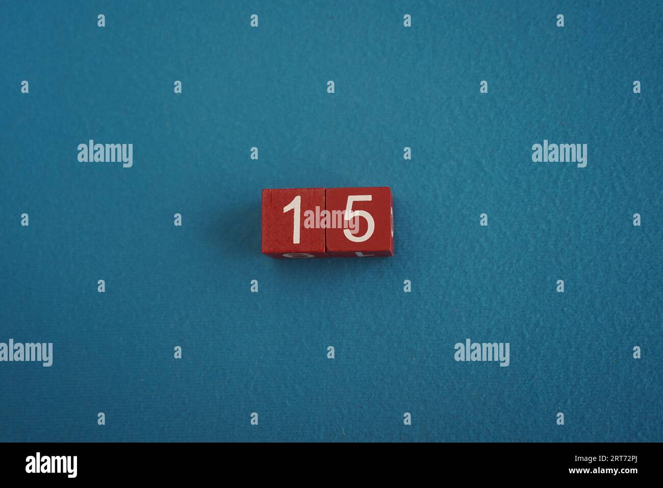 Wooden Viva Magenta cubes with number 15 on blue background close-up ...