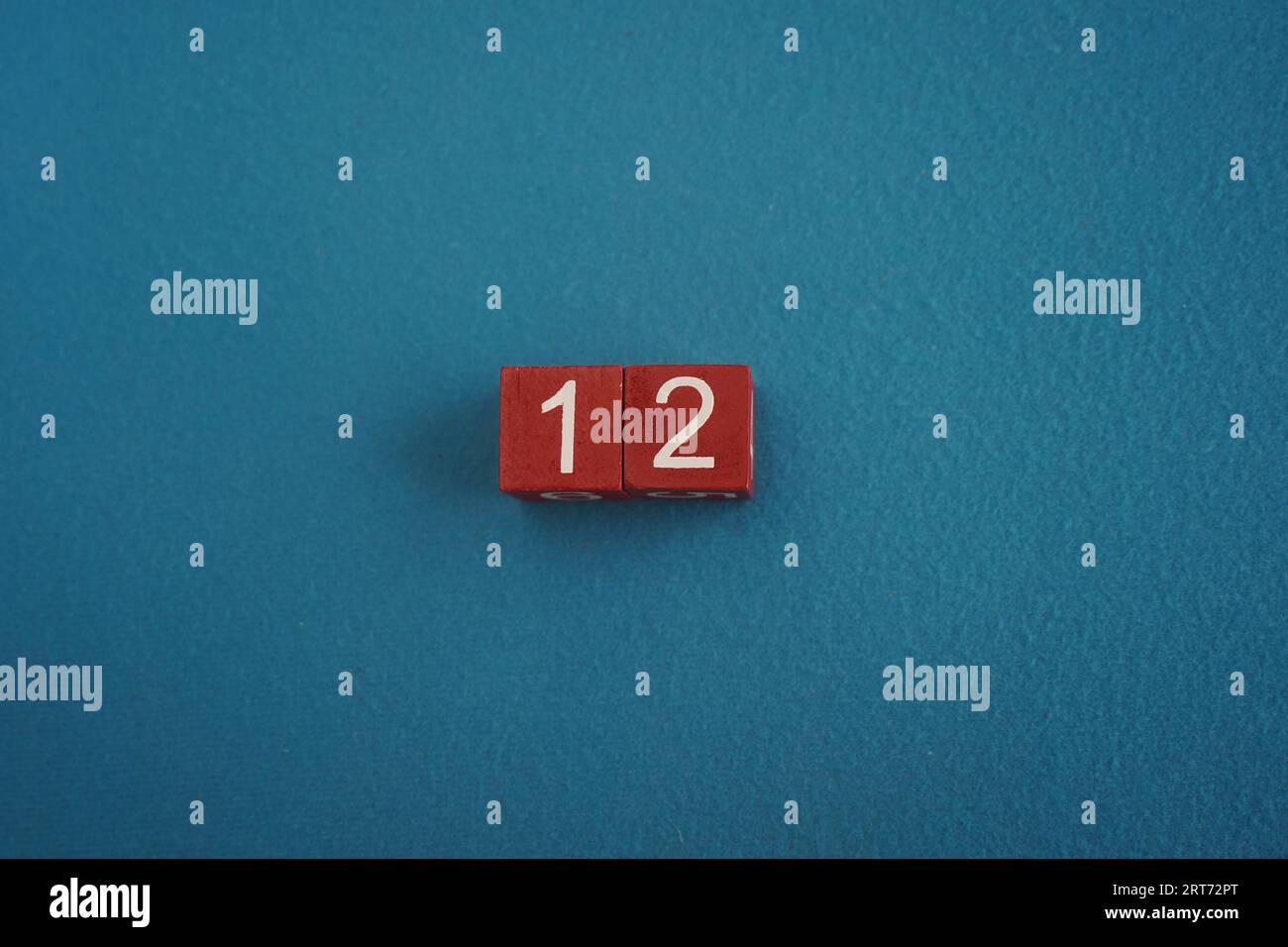 Wooden Viva Magenta cubes with number 12 on blue background close-up ...