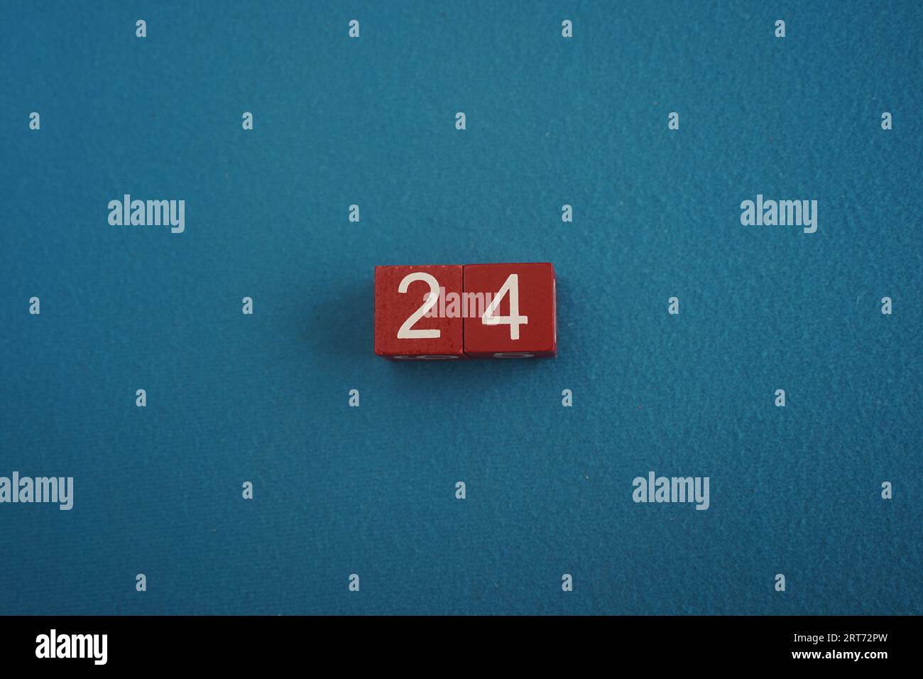 Wooden Viva Magenta cubes with number 24 on blue background close-up ...