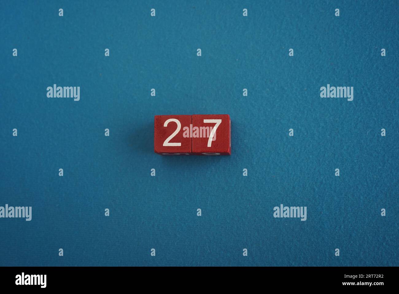 Wooden Viva Magenta cubes with number 27 on blue background close-up ...
