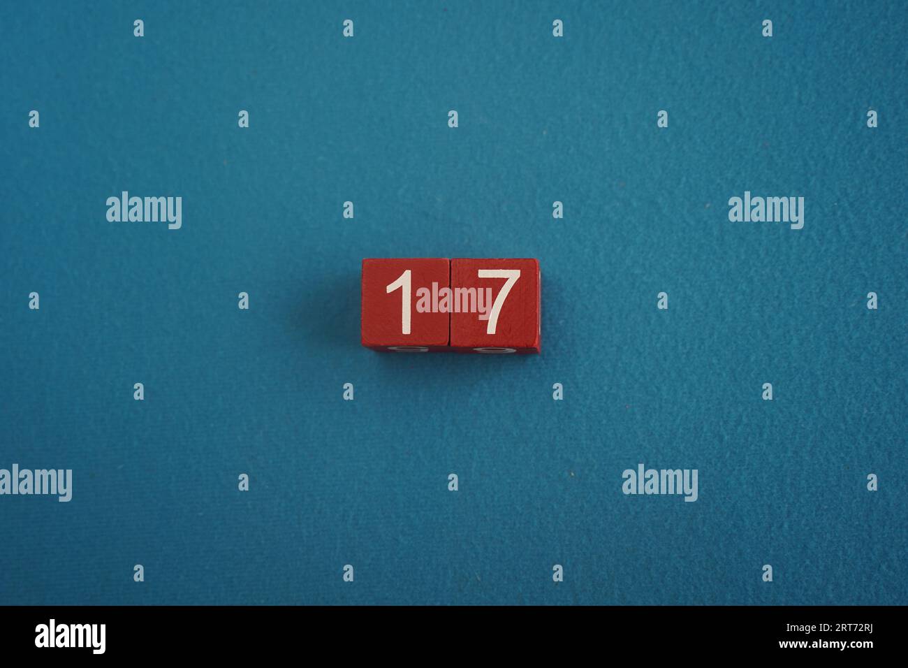 Wooden Viva Magenta cubes with number 17 on blue background close-up ...
