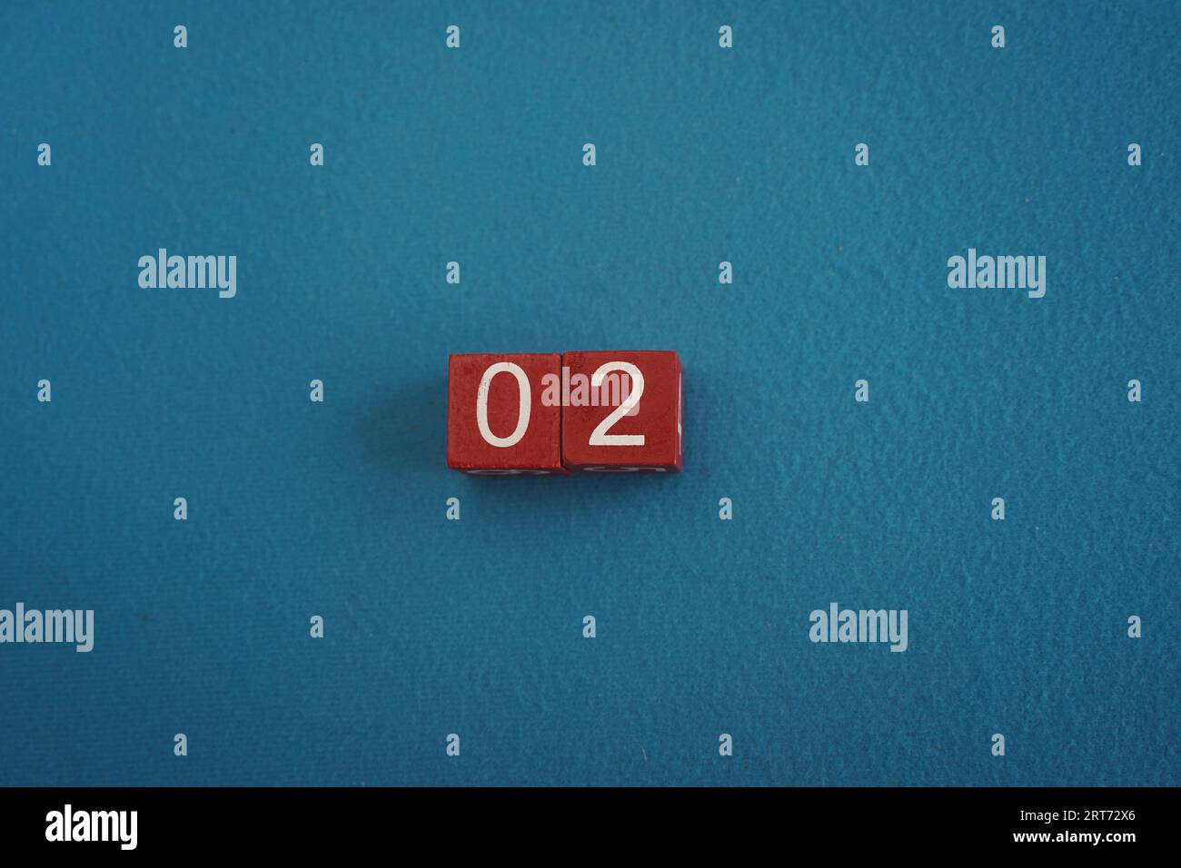 Wooden Viva Magenta cubes with number 02 on blue background close-up ...