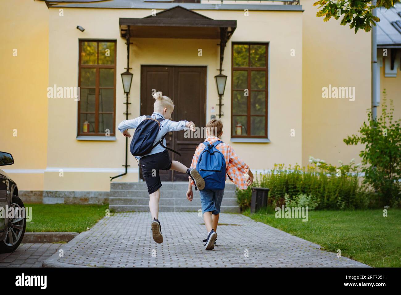 children running to school with backpacks on sunny day. Begining of ...