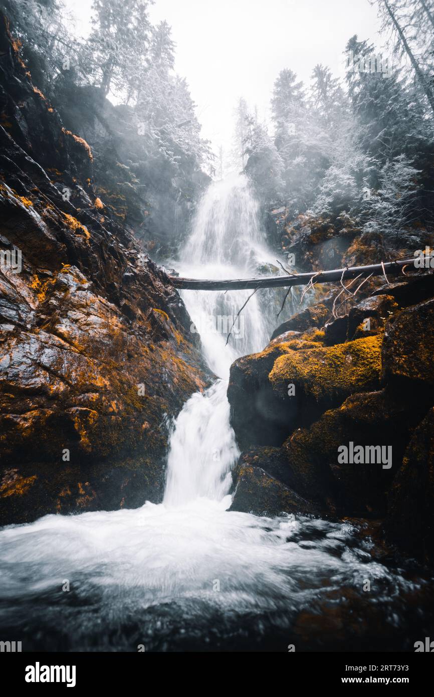 Beautiful and powerful snow covered waterfall with frozen and foggy ...