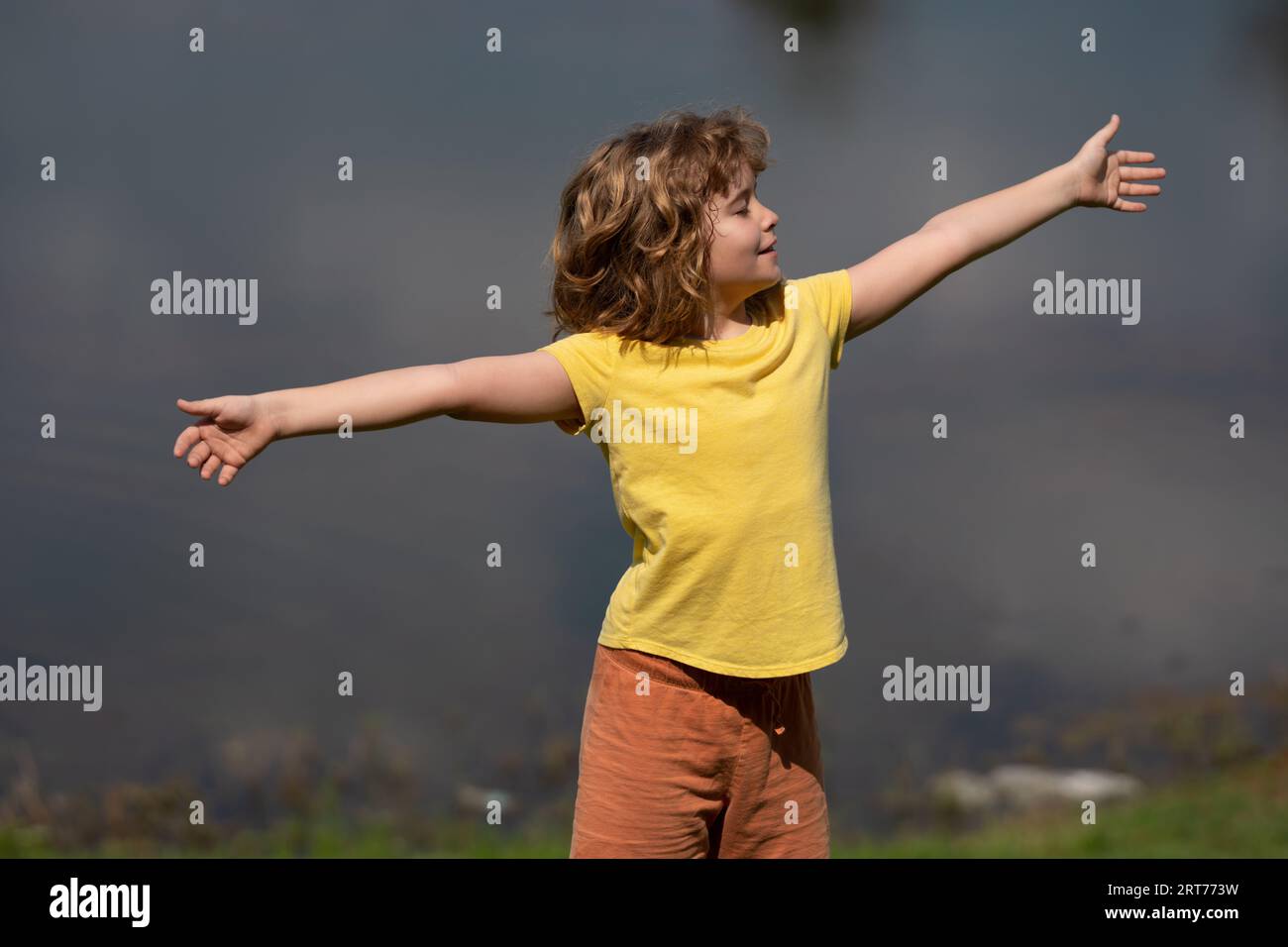 Happy child with arms up enjoying freedom in nature. Child with open ...