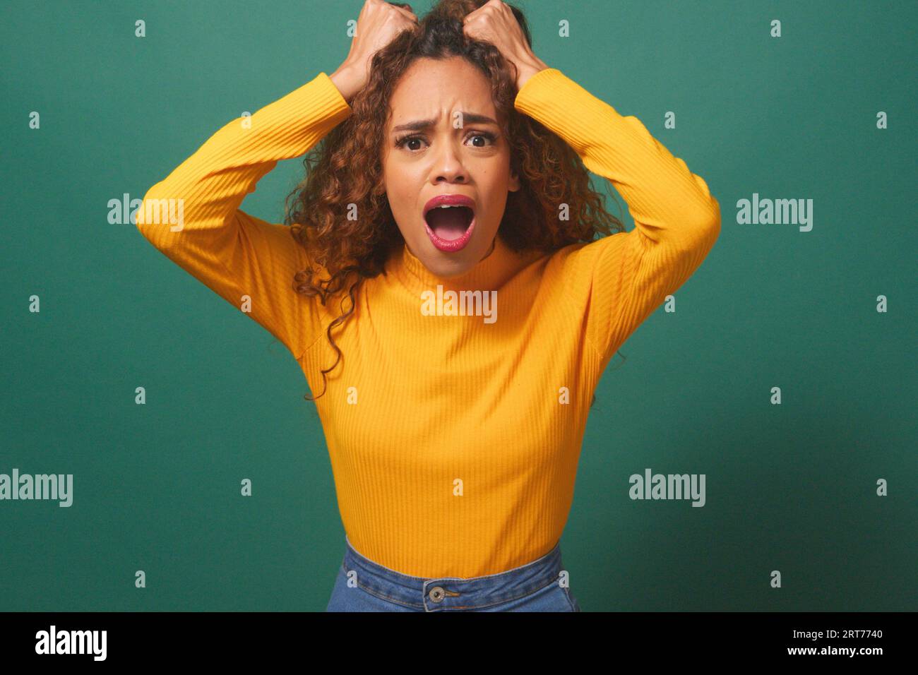 Frustrated and angry young woman 'tears hair out' - green studio ...