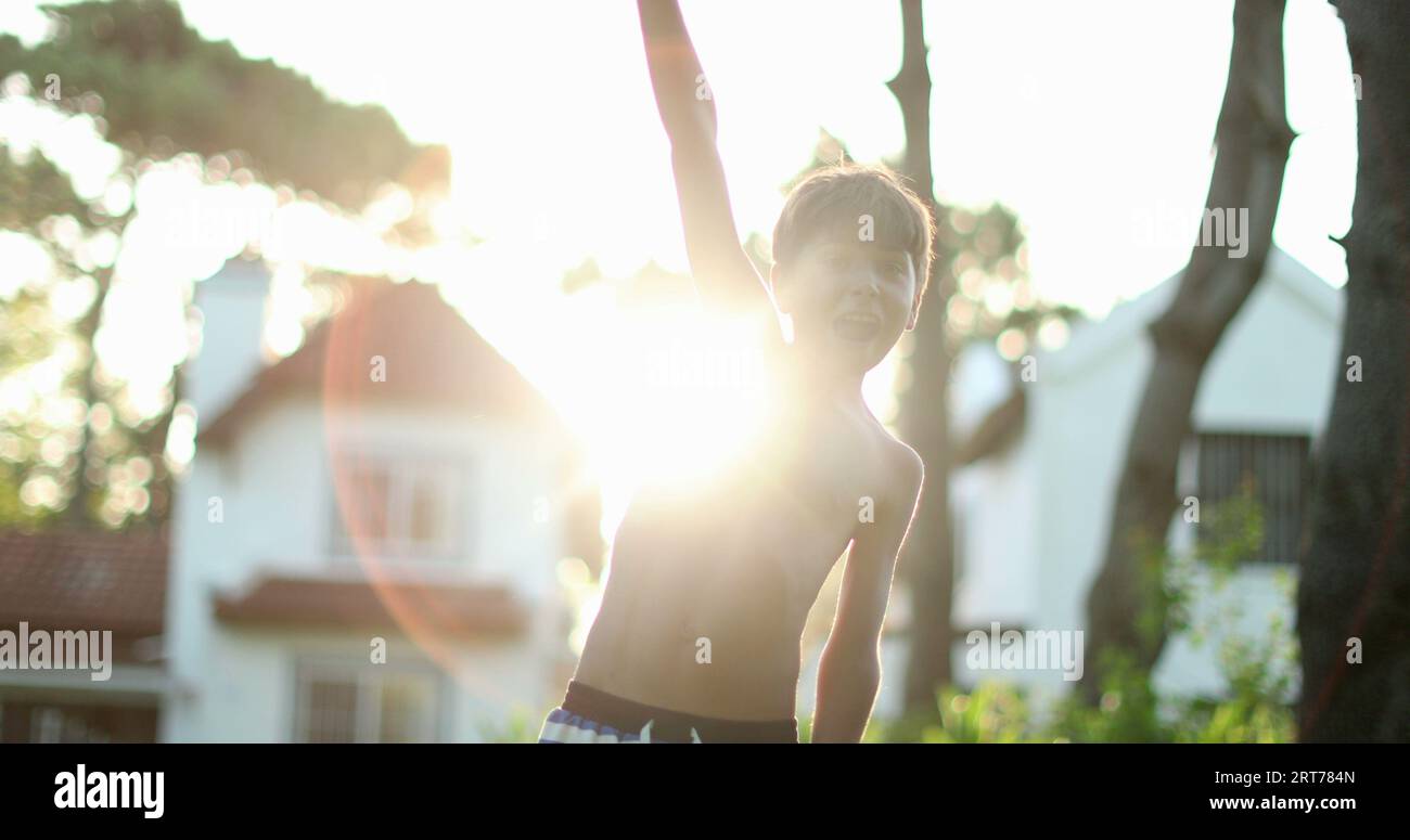 Boy raising arms in the sky clenching fists in victory and celebration ...