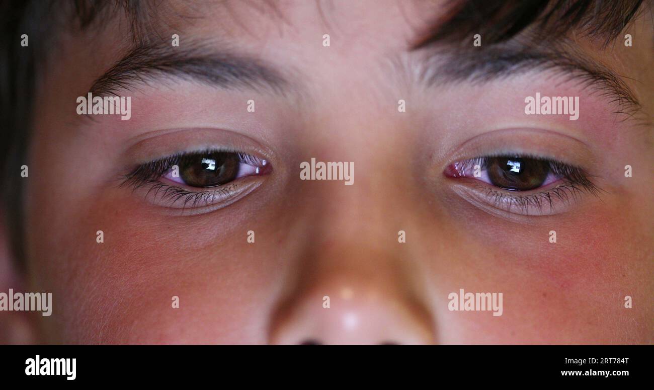 Boy eyes macro close-up watching content online. Child staring at blue ...