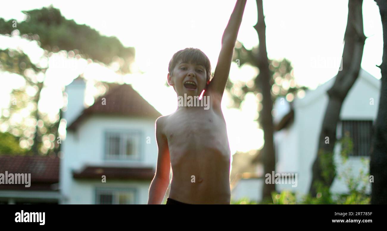 Boy raising arms in the sky clenching fists in victory and celebration ...