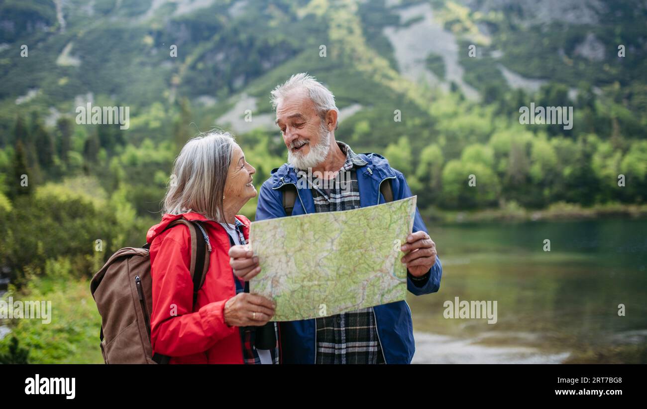 Senior tourists with backpacks reading map, preparing for hike Stock ...