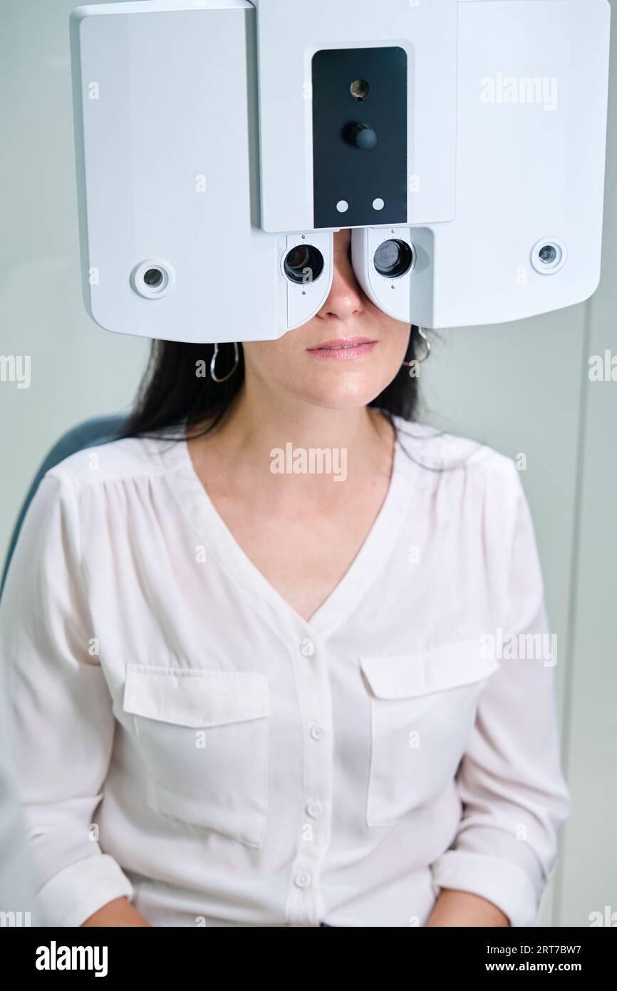 Adult woman taking digital refraction test at optometry clinic Stock ...