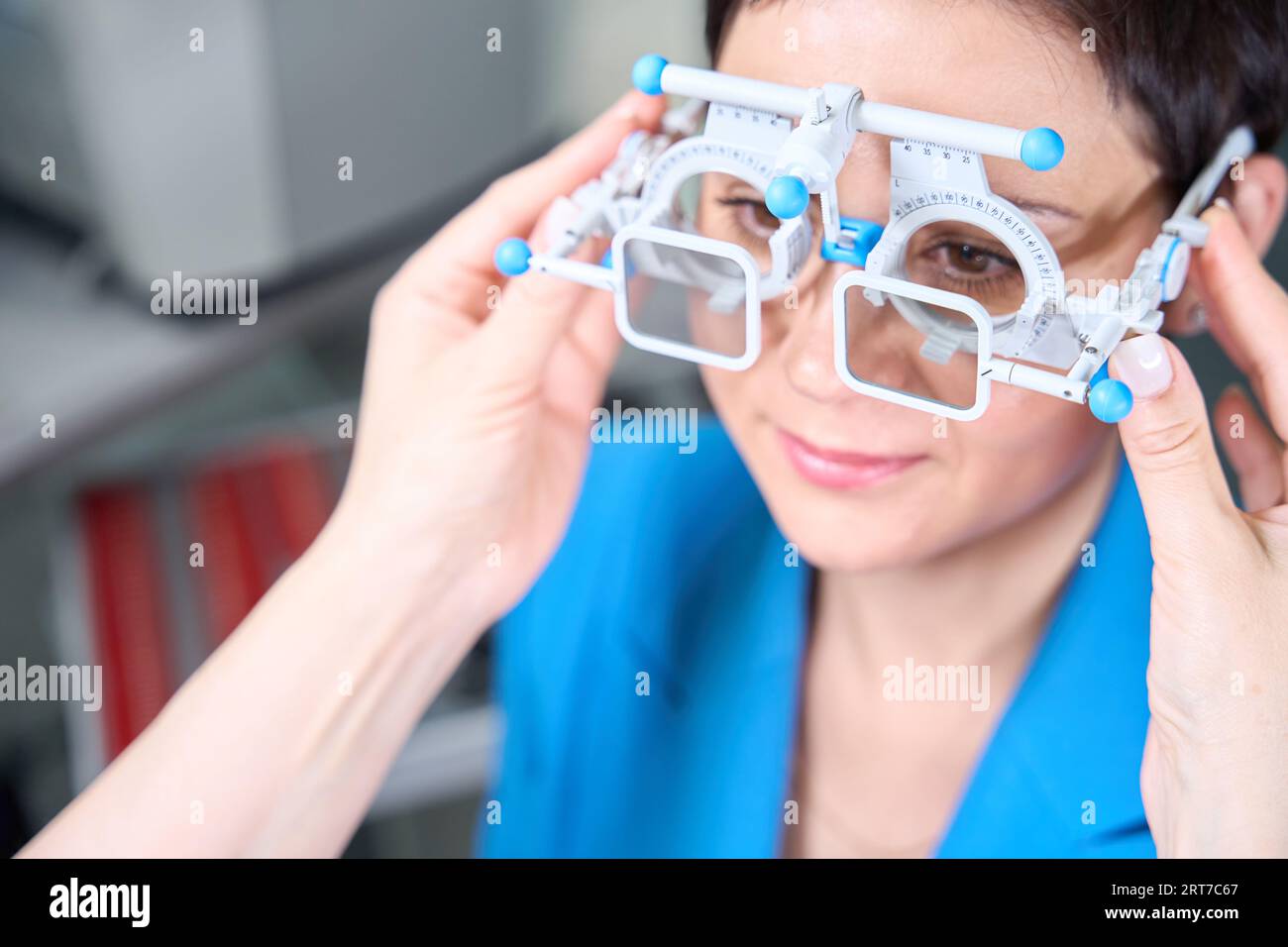 Vision specialist preparing female patient for subjective refraction ...