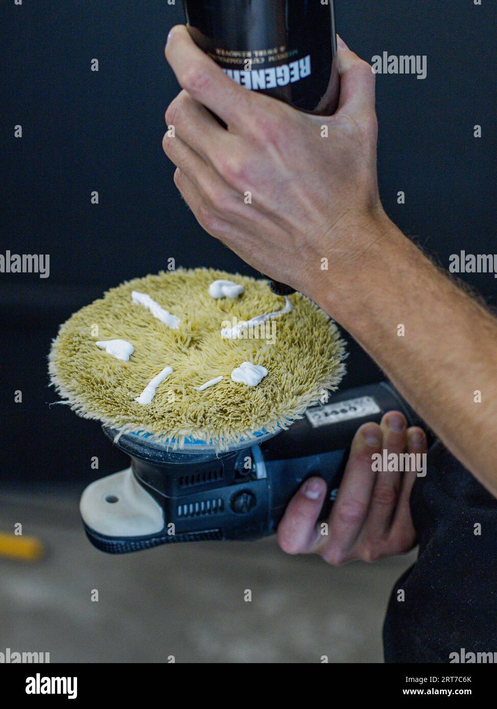 A close-up view of a woman using a handheld drill to decorate a creamy ...