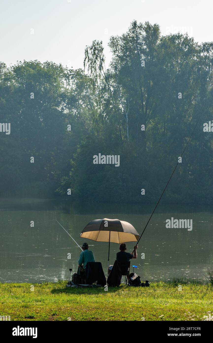 Nijmegen, Netherlands. 10th Sep, 2023. Two men are seen fishing on a ...